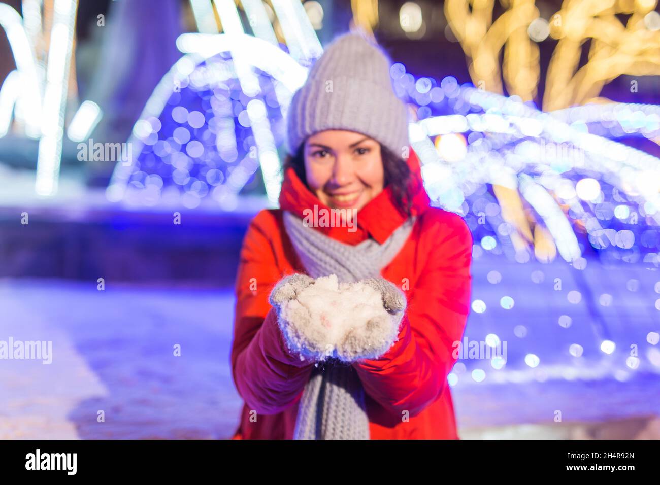 Happy funny young woman with winter clothes background evening city ...