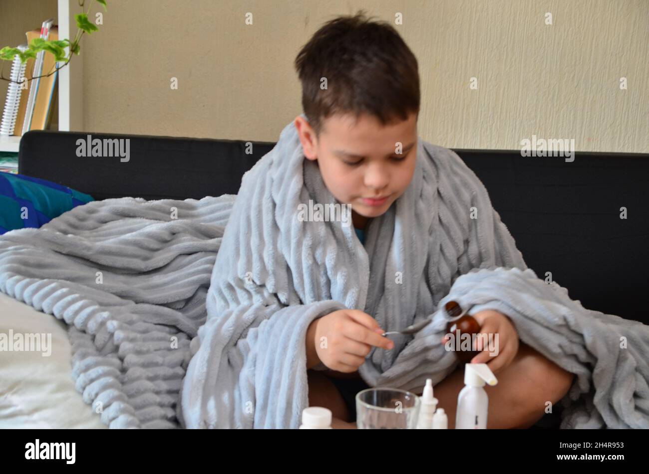 Sick child boy lying in bed with a fever, resting at home. a boy with a ...