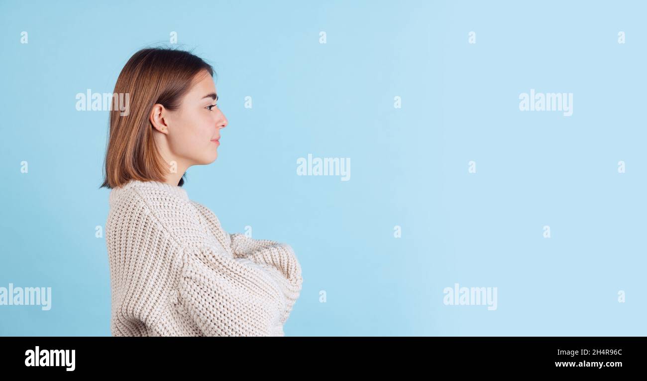 Side view of young cute girl, student in casual clothes looks straight ...