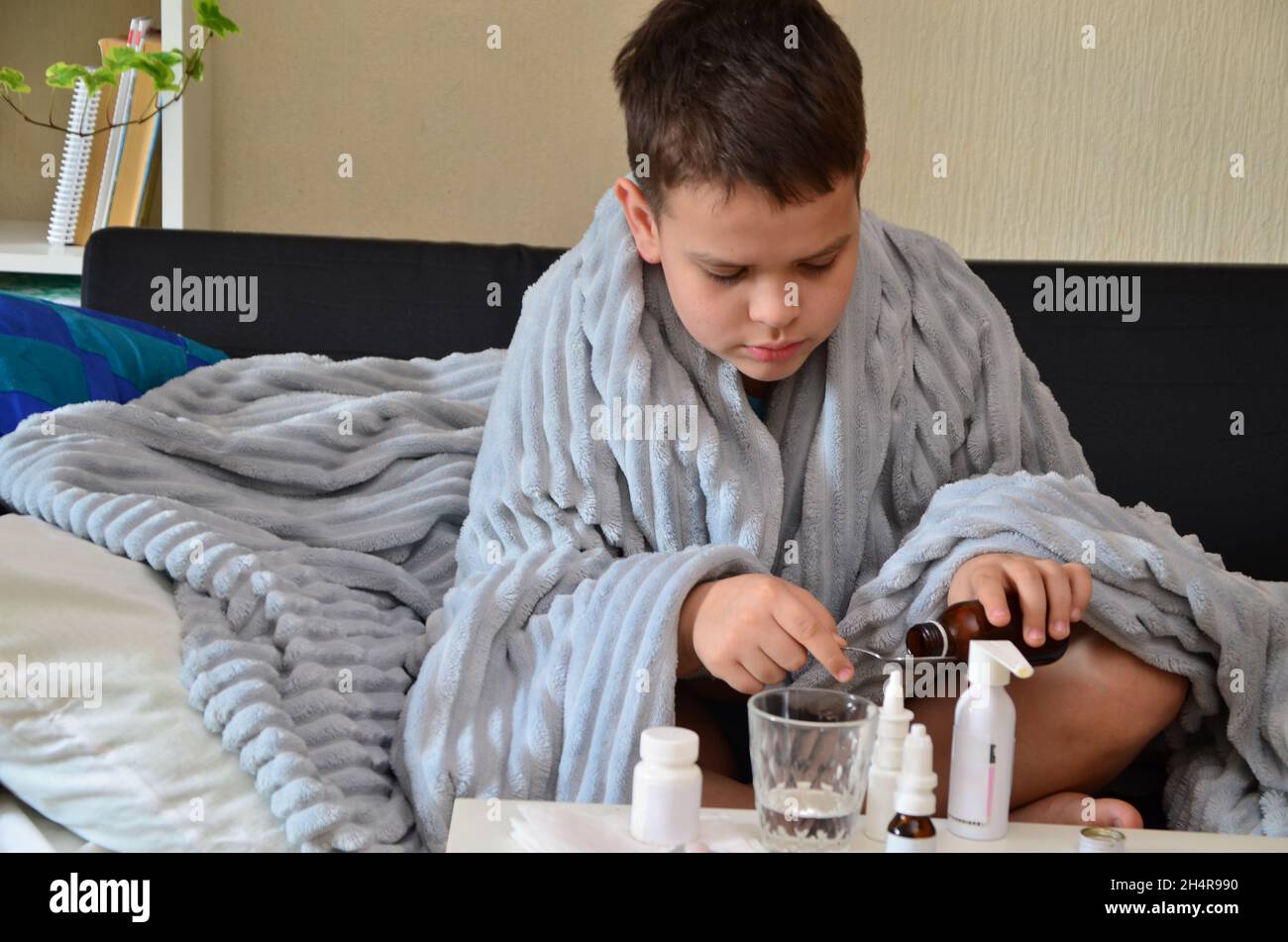 Sick child boy lying in bed with a fever, resting at home. a boy with a ...