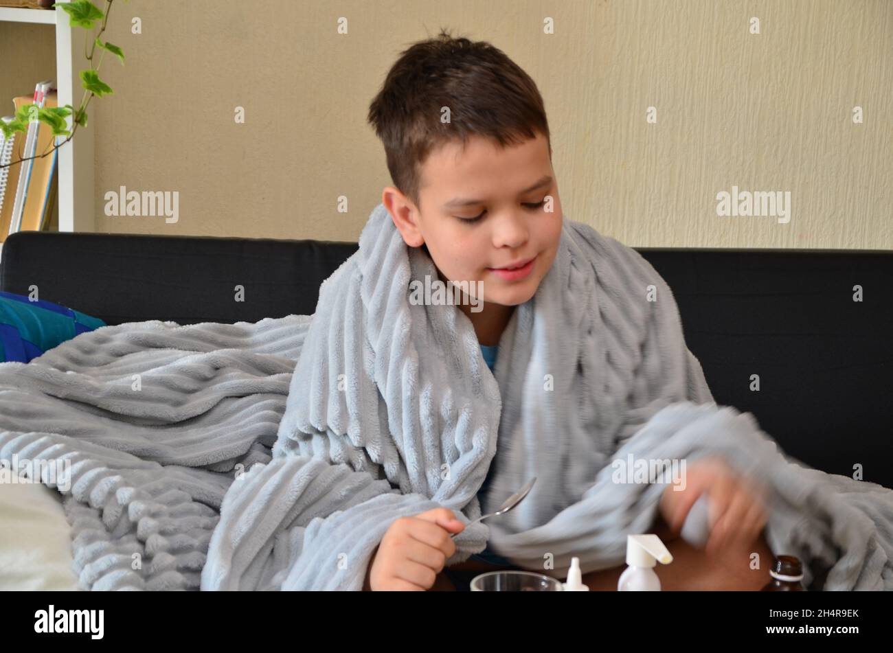 Sick child boy lying in bed with a fever, resting at home. a boy with a ...