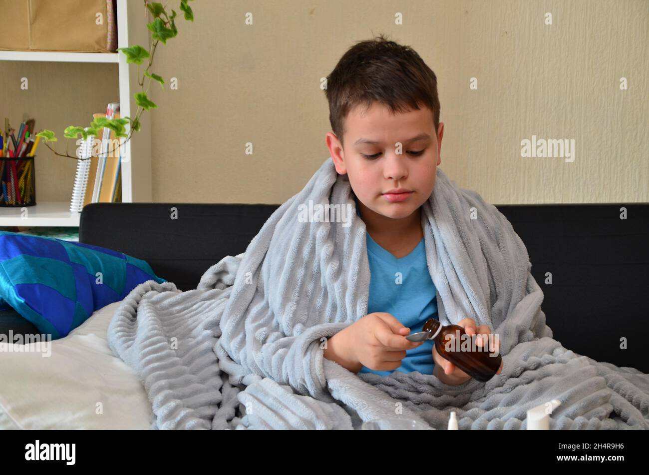 Sick child boy lying in bed with a fever, resting at home. a boy with a ...