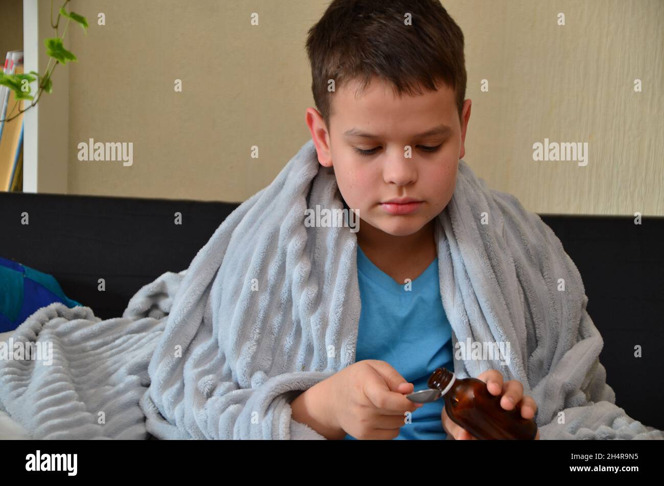 Sick child boy lying in bed with a fever, resting at home. a boy with a ...