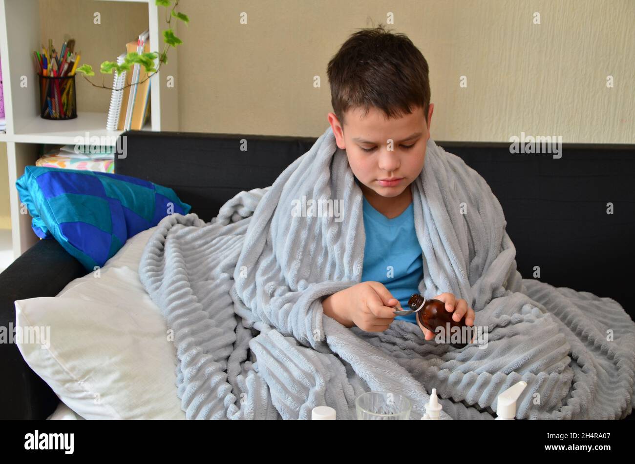 Sick child boy lying in bed with a fever, resting at home. a boy with a ...