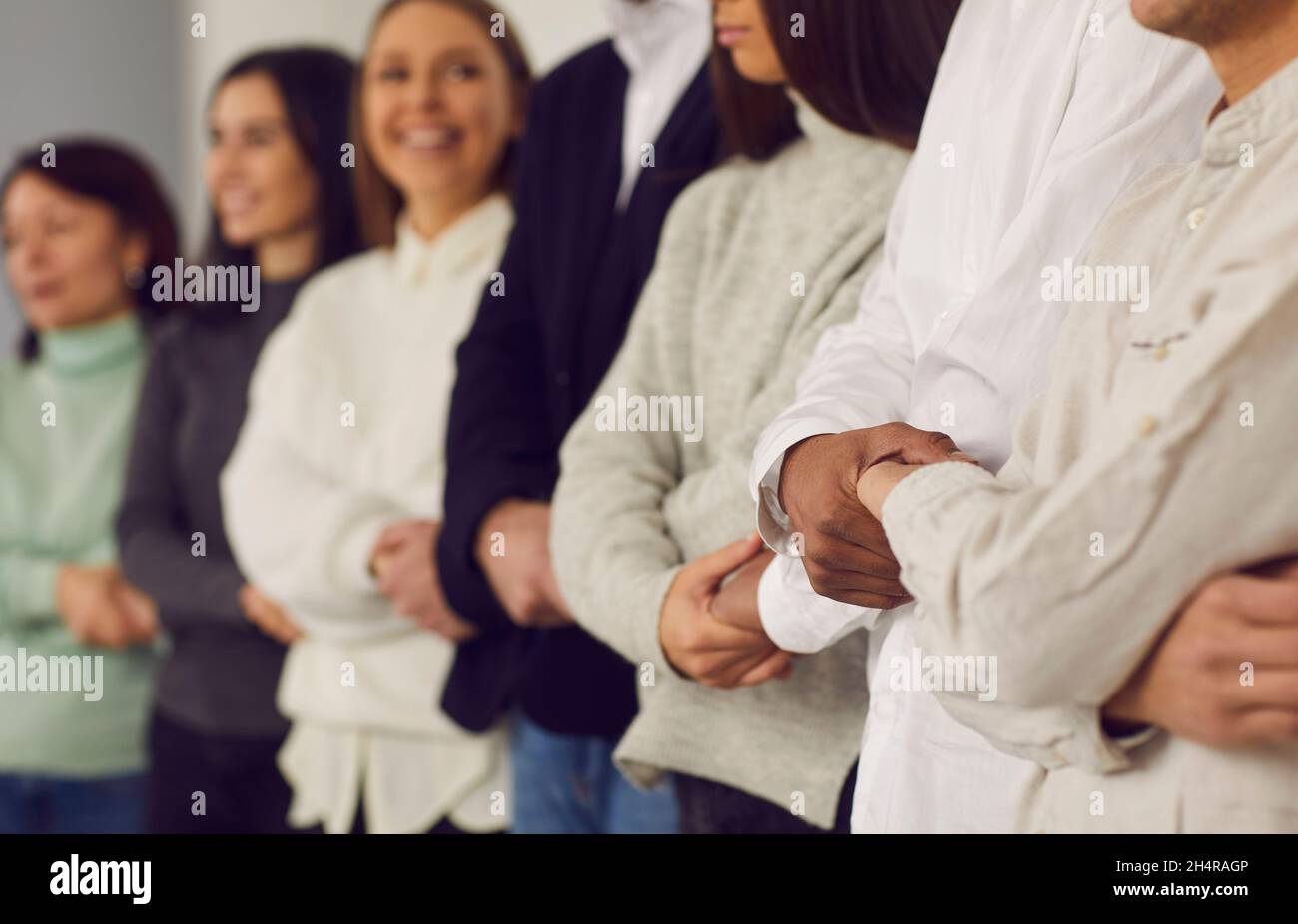 Happy company employees standing together and holding hands, feeling ...