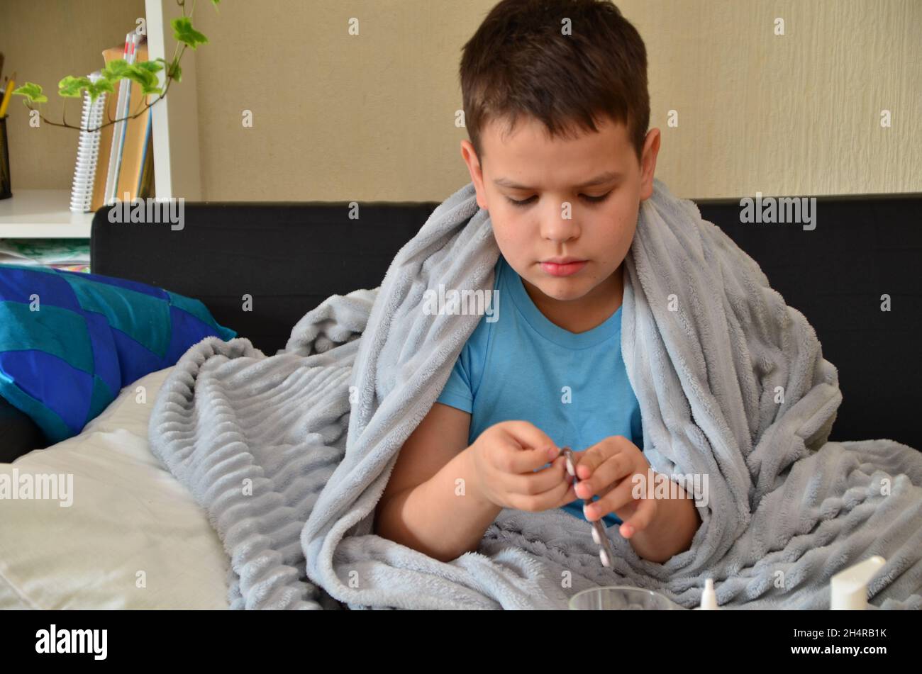 Sick child boy lying in bed with a fever, resting at home. a boy with a ...