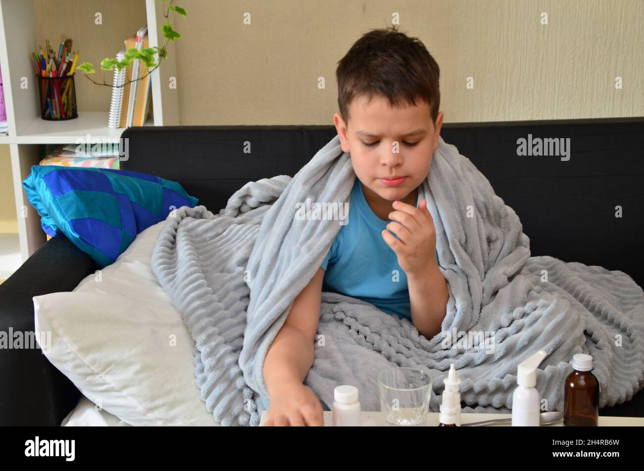 Sick child boy lying in bed with a fever, resting at home. a boy with a ...