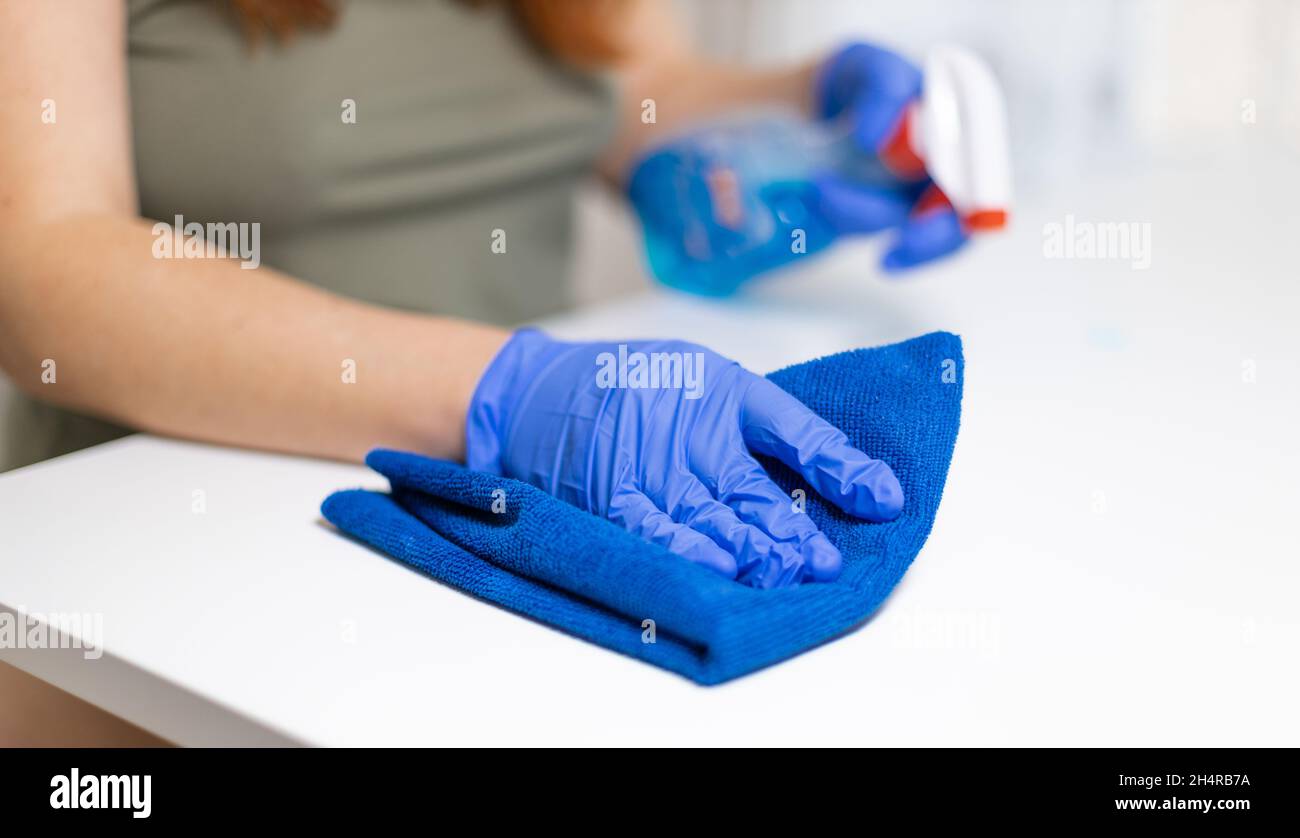 Close up of cleaning white table, sanitizing table surface with ...