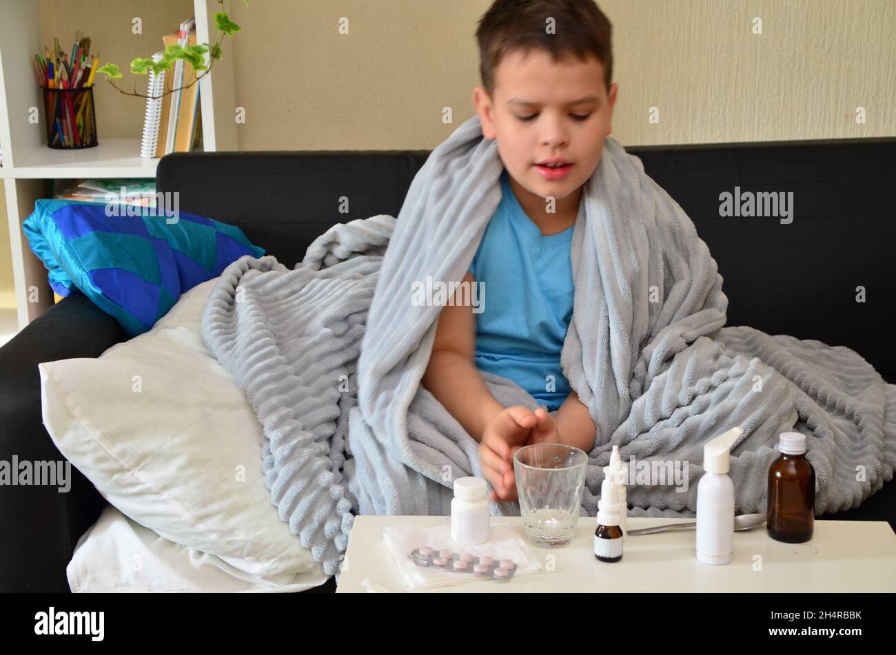Sick child boy lying in bed with a fever, resting at home. a boy with a ...