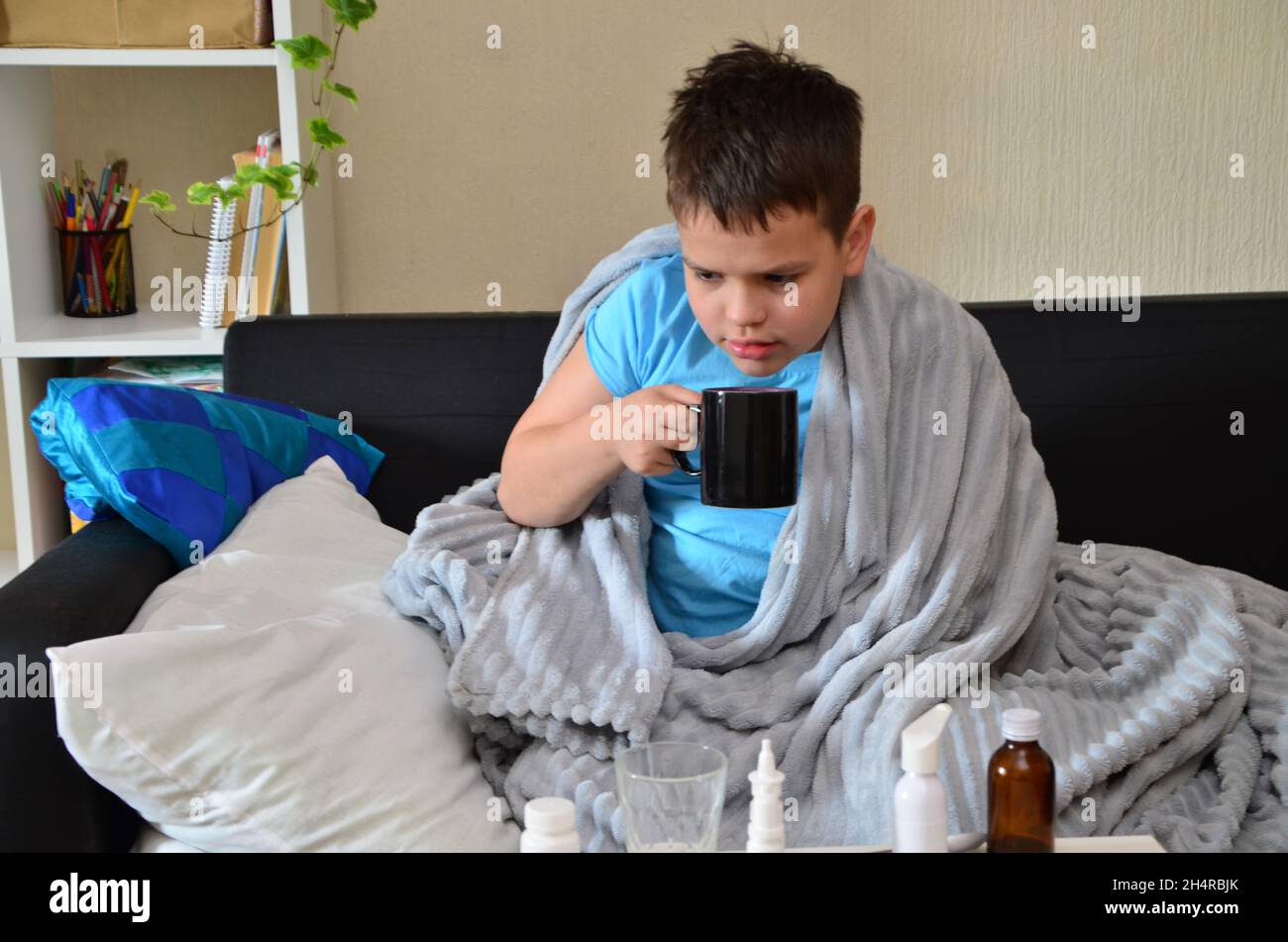 Sick child boy lying in bed with a fever, resting at home. a boy with a ...