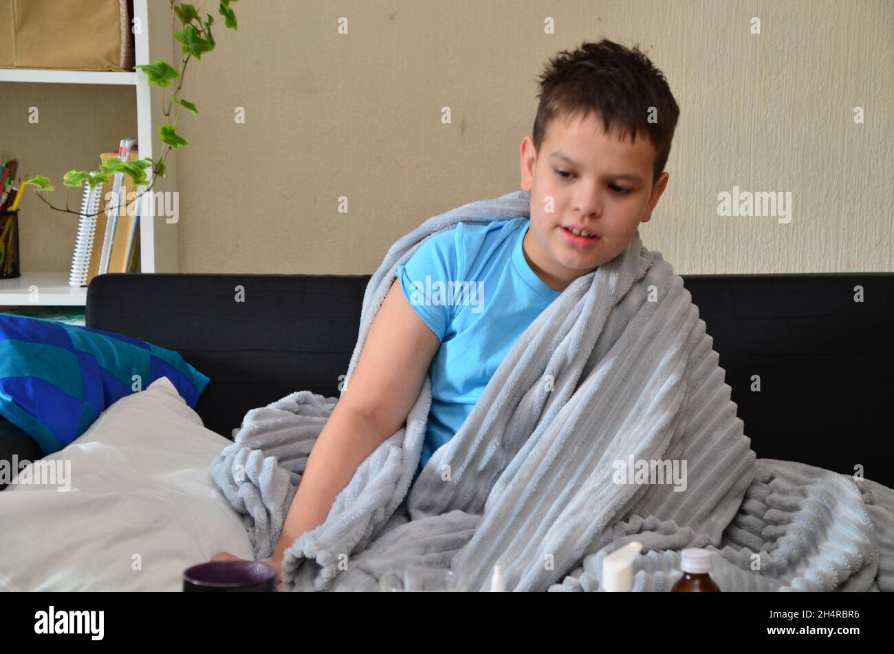 Sick child boy lying in bed with a fever, resting at home. a boy with a ...