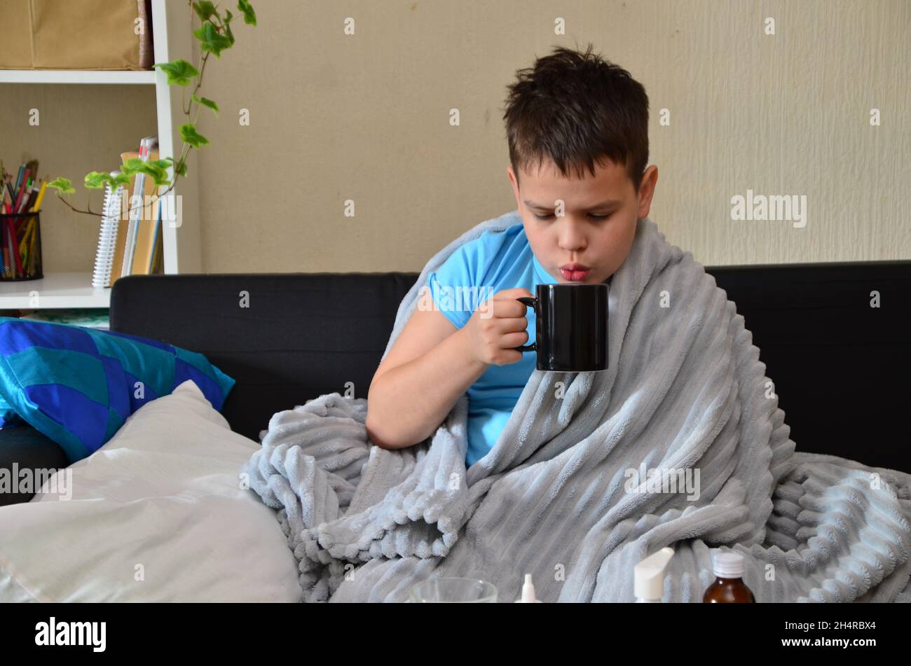 Sick child boy lying in bed with a fever, resting at home. a boy with a ...