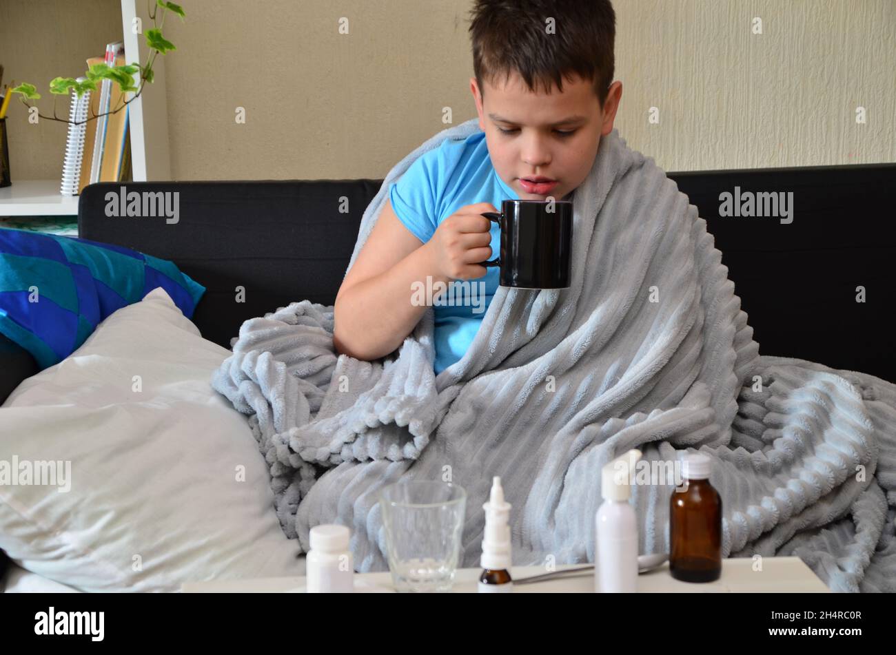 Sick child boy lying in bed with a fever, resting at home. a boy with a ...