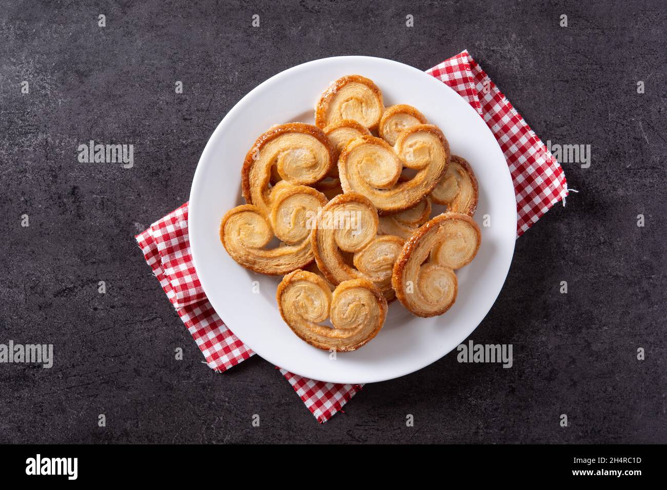 Palmier puff pastry in plate on black slate background Stock Photo - Alamy