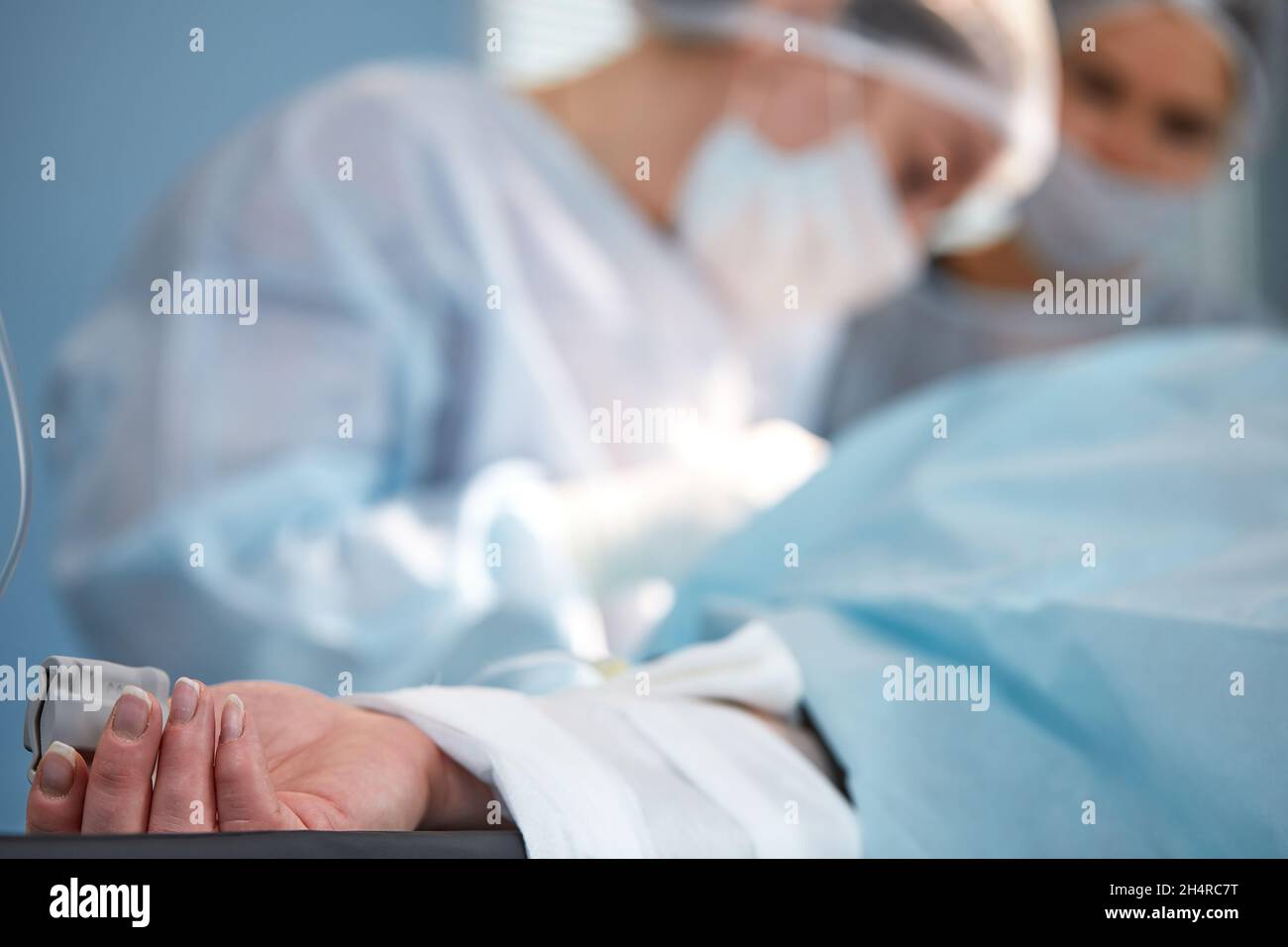 The patient's hand is under the IV with a pulse oximeter on the finger ...