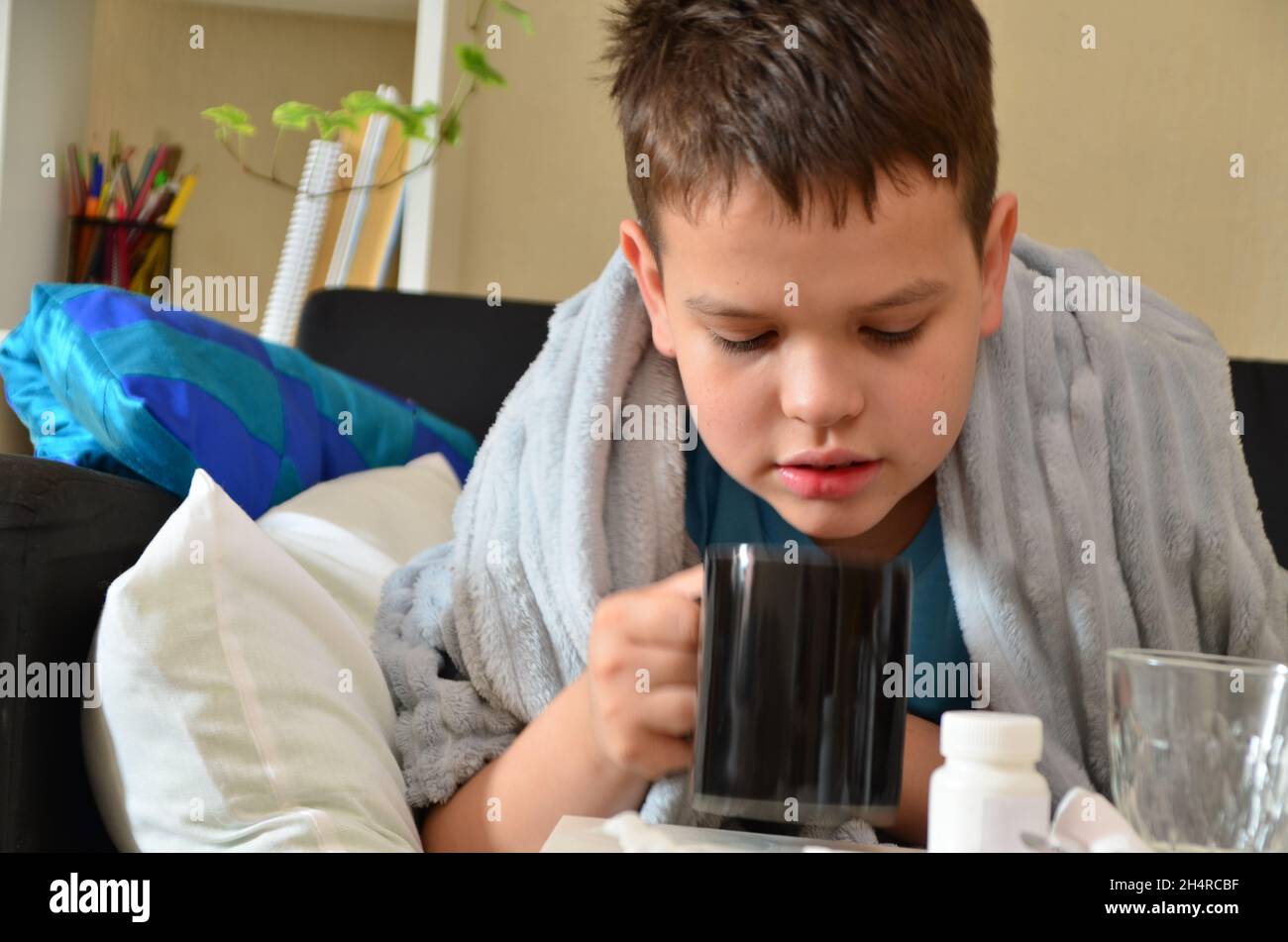 Sick child boy lying in bed with a fever, resting at home. a boy with a ...