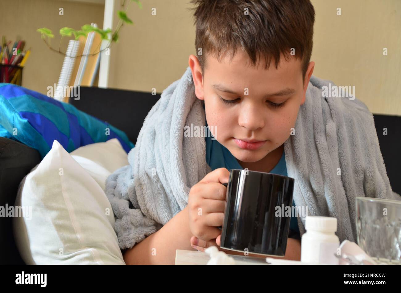 Sick child boy lying in bed with a fever, resting at home. a boy with a ...