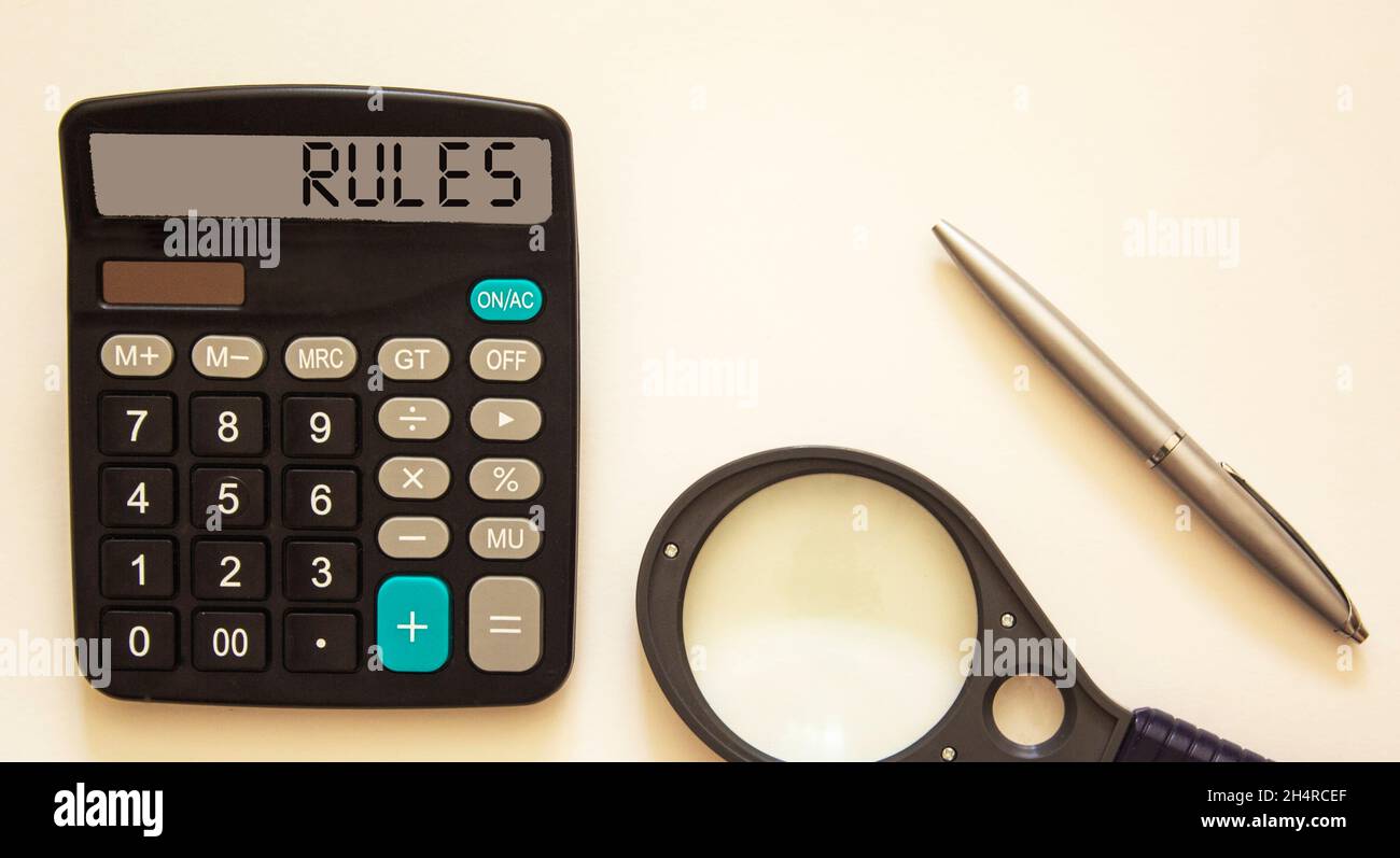 Calculator with the text RULES on a white background with a magnifying ...