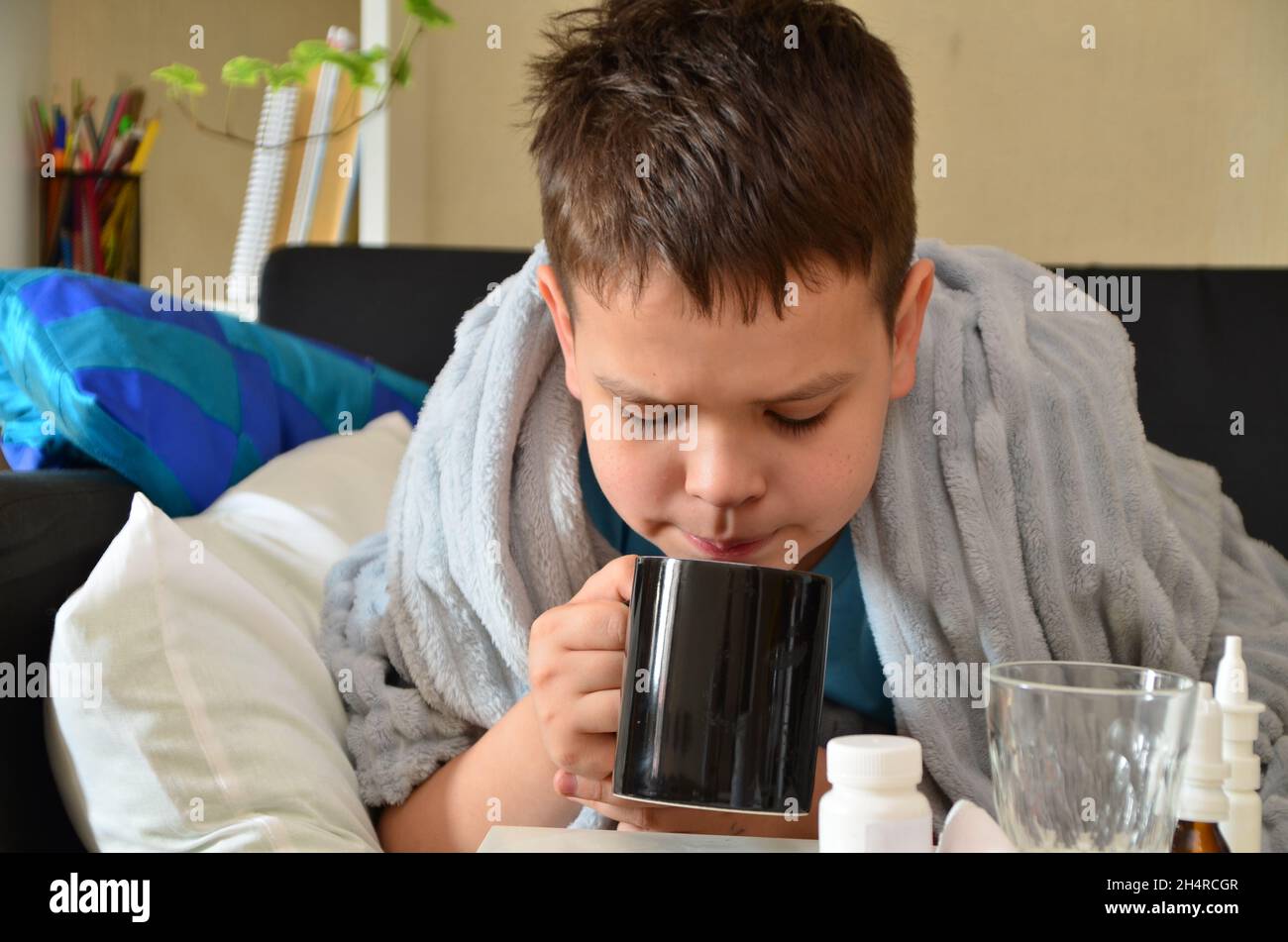 Sick child boy lying in bed with a fever, resting at home. a boy with a ...