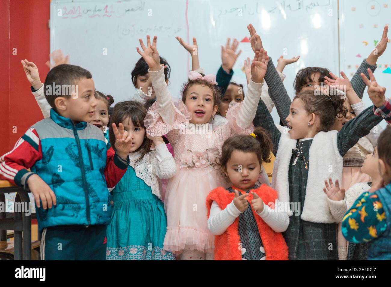 Portrait of little children playing colorful blocks in classroom ...