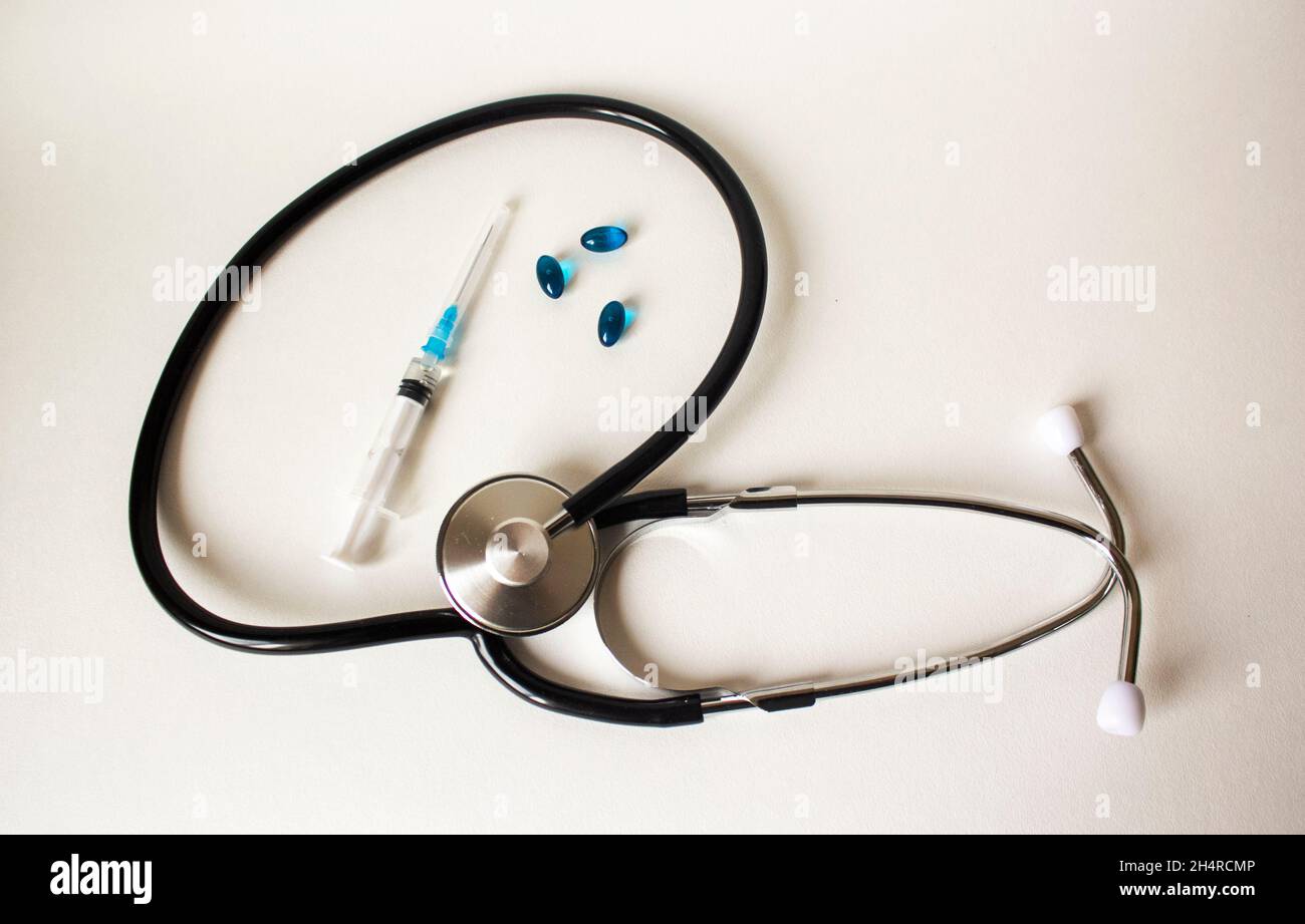 Stethoscope of various pills and injections on a white background ...