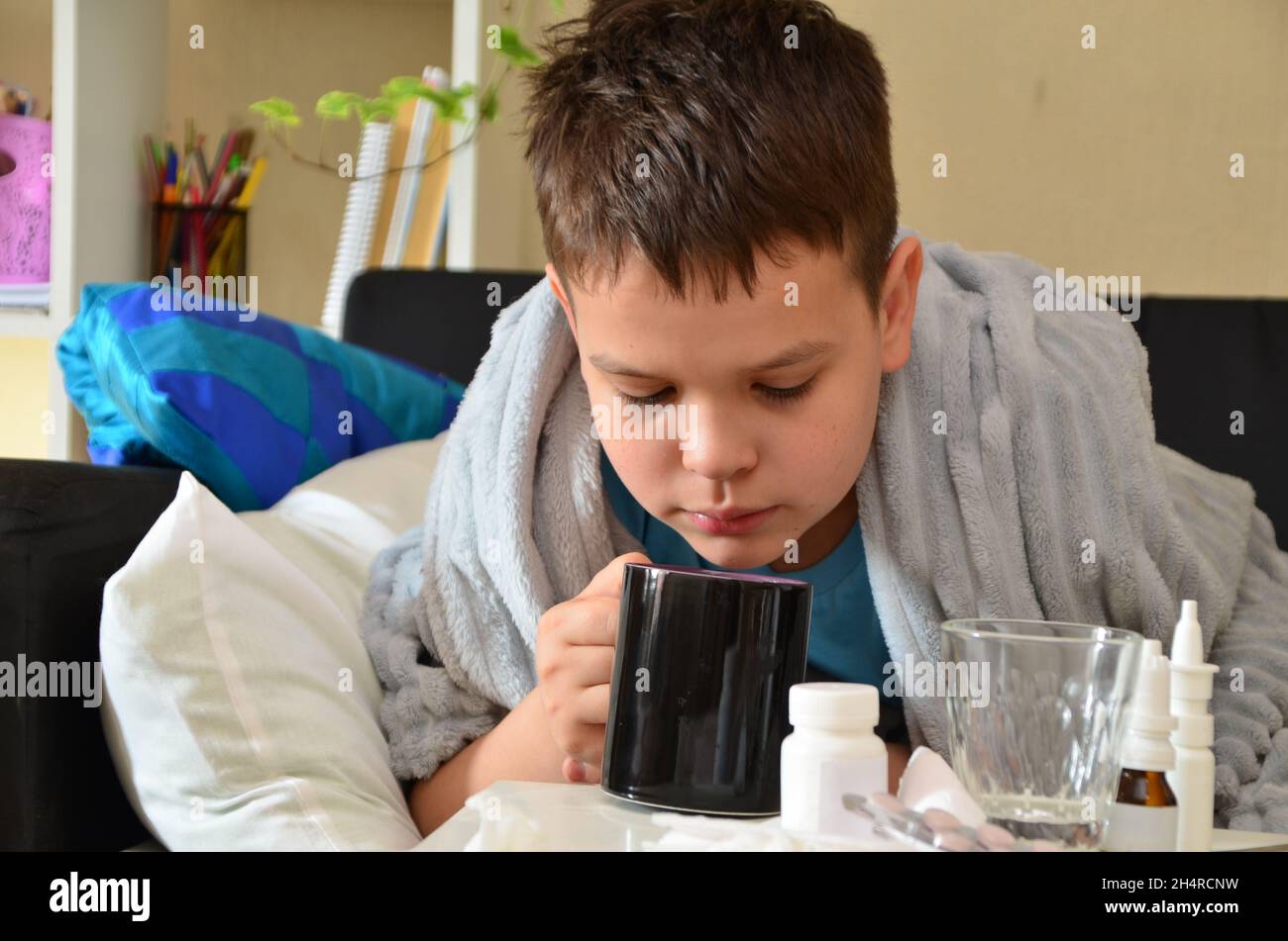 Sick child boy lying in bed with a fever, resting at home. a boy with a ...