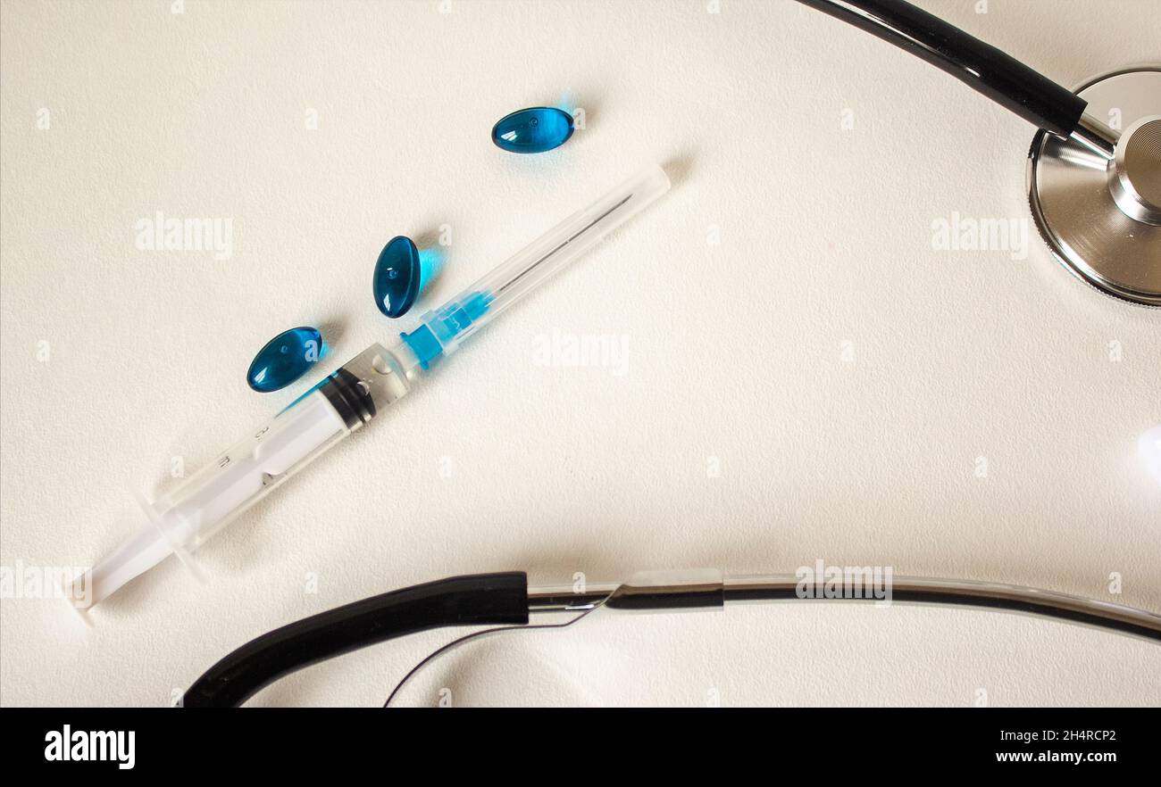 Stethoscope of various pills and injections on a white background ...