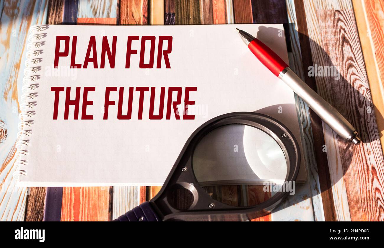 text PLAN FOR THE FUTURE written on a notebook, near a magnifying glass ...