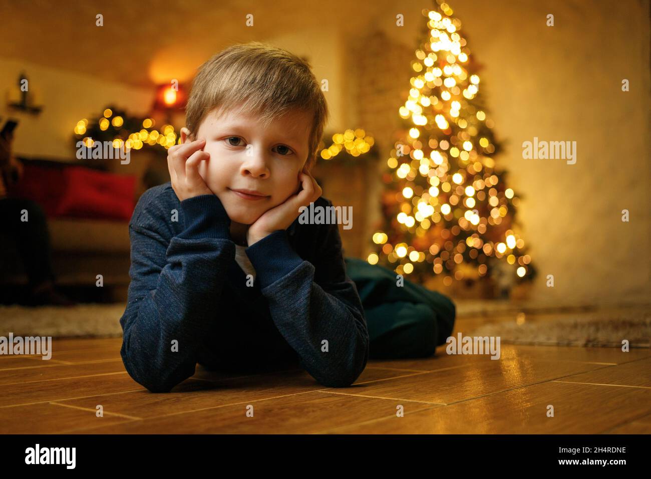 Portrait of a smiling cute boy 5-7 years old lying on the floor against ...