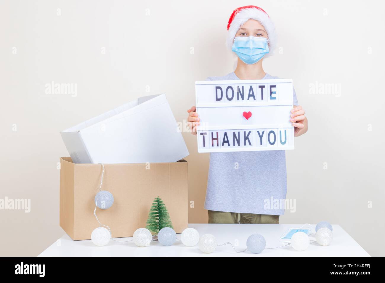 Christmas donation, charity. Kid volunteer with Santa hat and medical ...