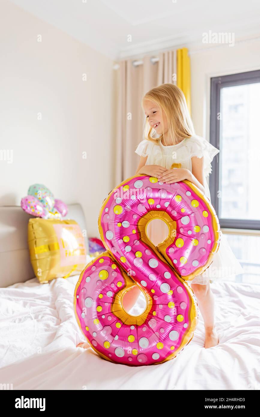 Indoor shot of pretty joyful cute adorable girl kid celebrating eight ...