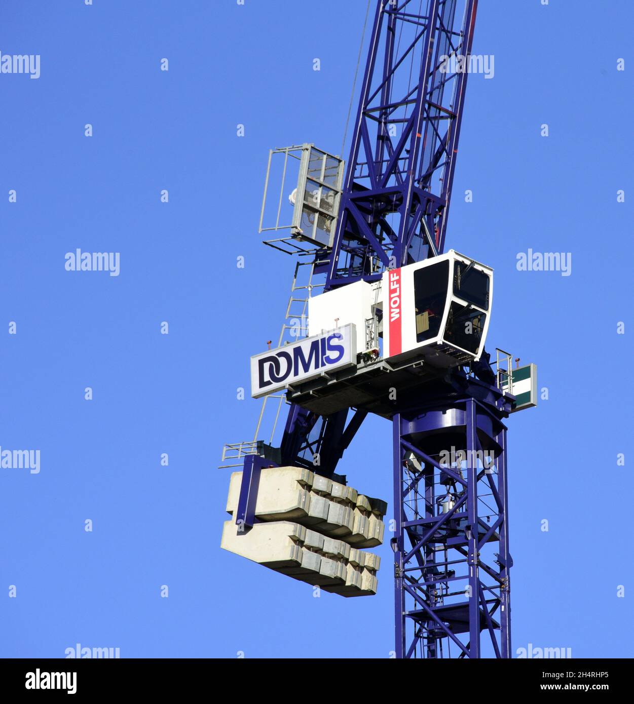 A tower crane cab in Manchester, UK, with Domis Construction sign on ...
