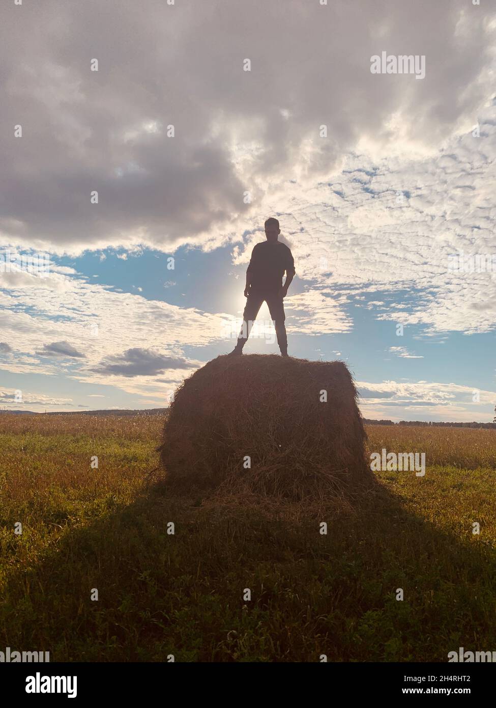 Man stand on stack of hey. Freedom concept Stock Photo - Alamy