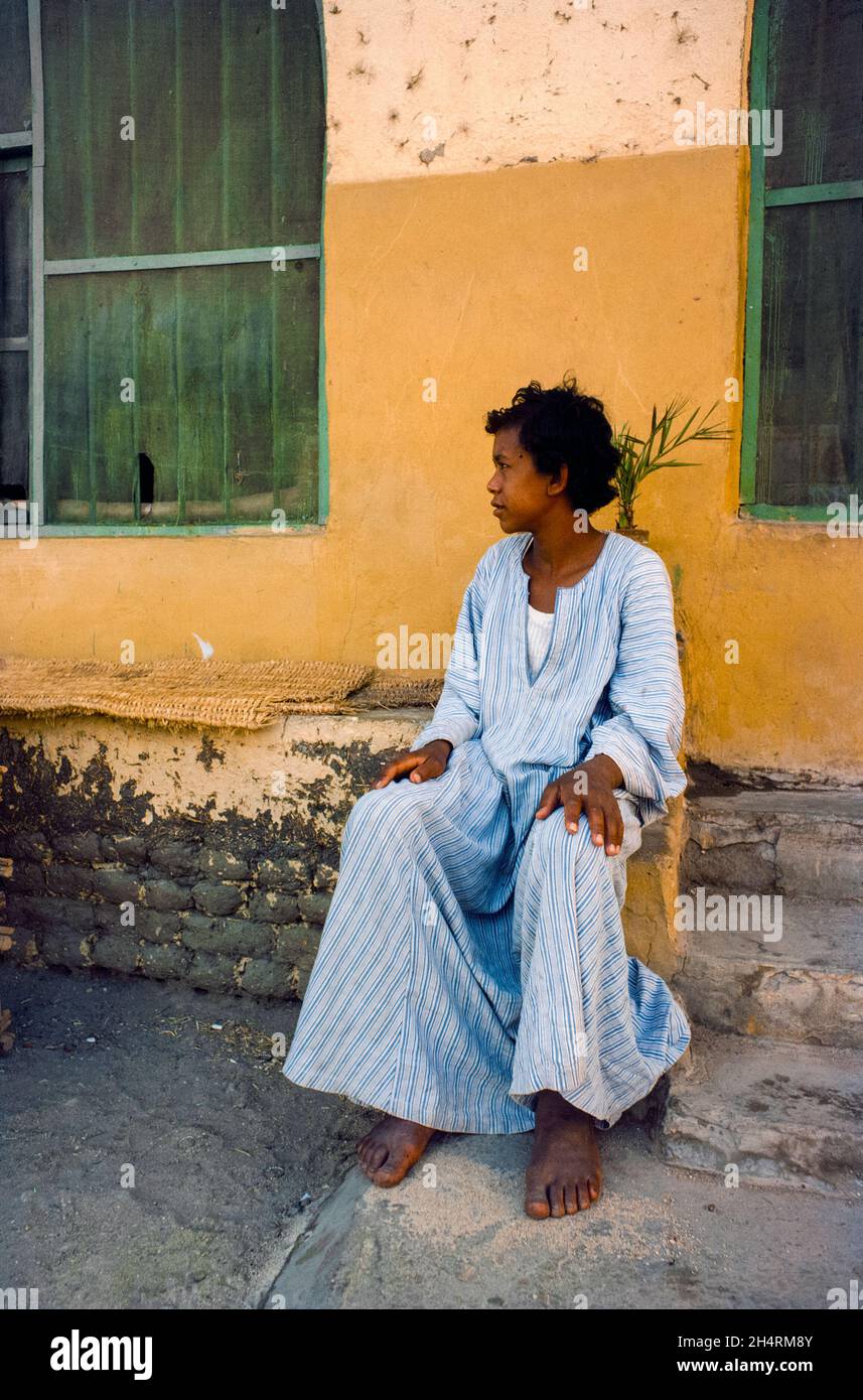 Africa, Egypt 1976. A boy sitting outside a house on the west bank of ...