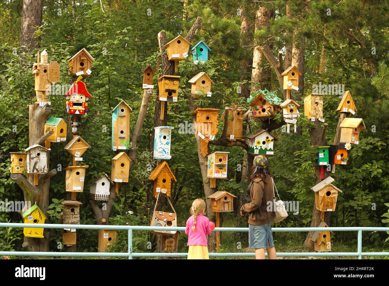 Multi-colored bright wooden birdhouses set in the park as decorations ...
