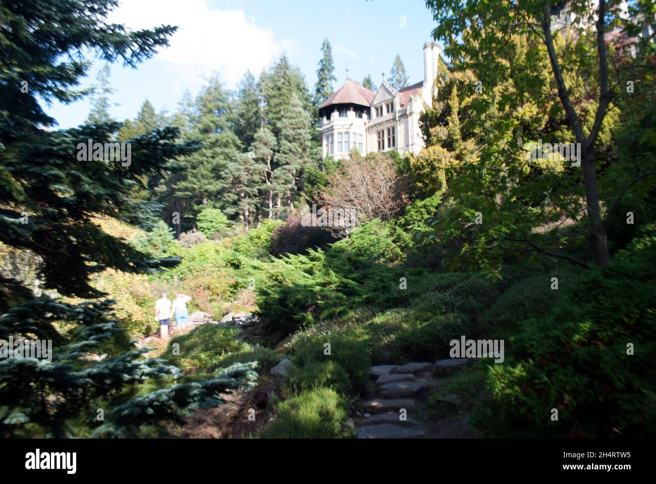 Two people looking up at Cragside House and Rockery, Rothbury ...