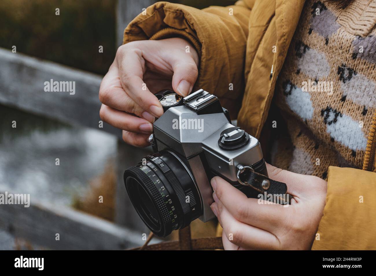 Close-up cropped photo of woman holding vintage camera, turning dial ...