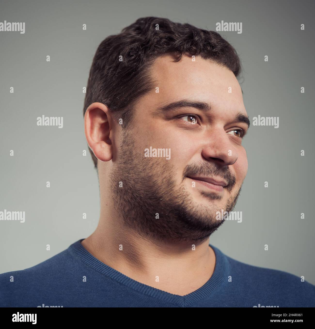 young positive man portrait in blue sweater at studio background Stock ...