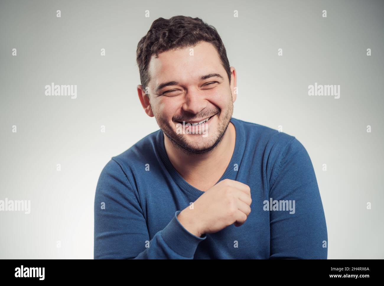 young laughing man portrait in blue sweater at studio background Stock ...