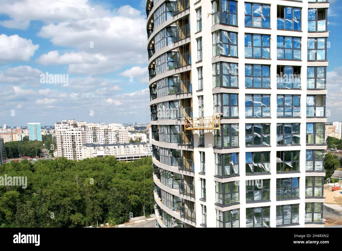 Suspended cradle for works of the facade of skyscraper. Construction of ...