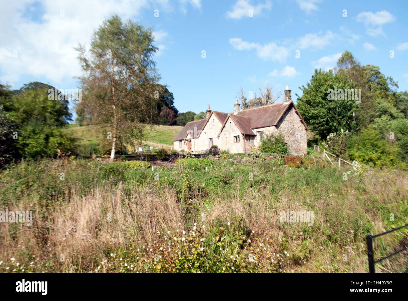 Stone holiday cottage, field and trees at Cragside, Rothbury ...