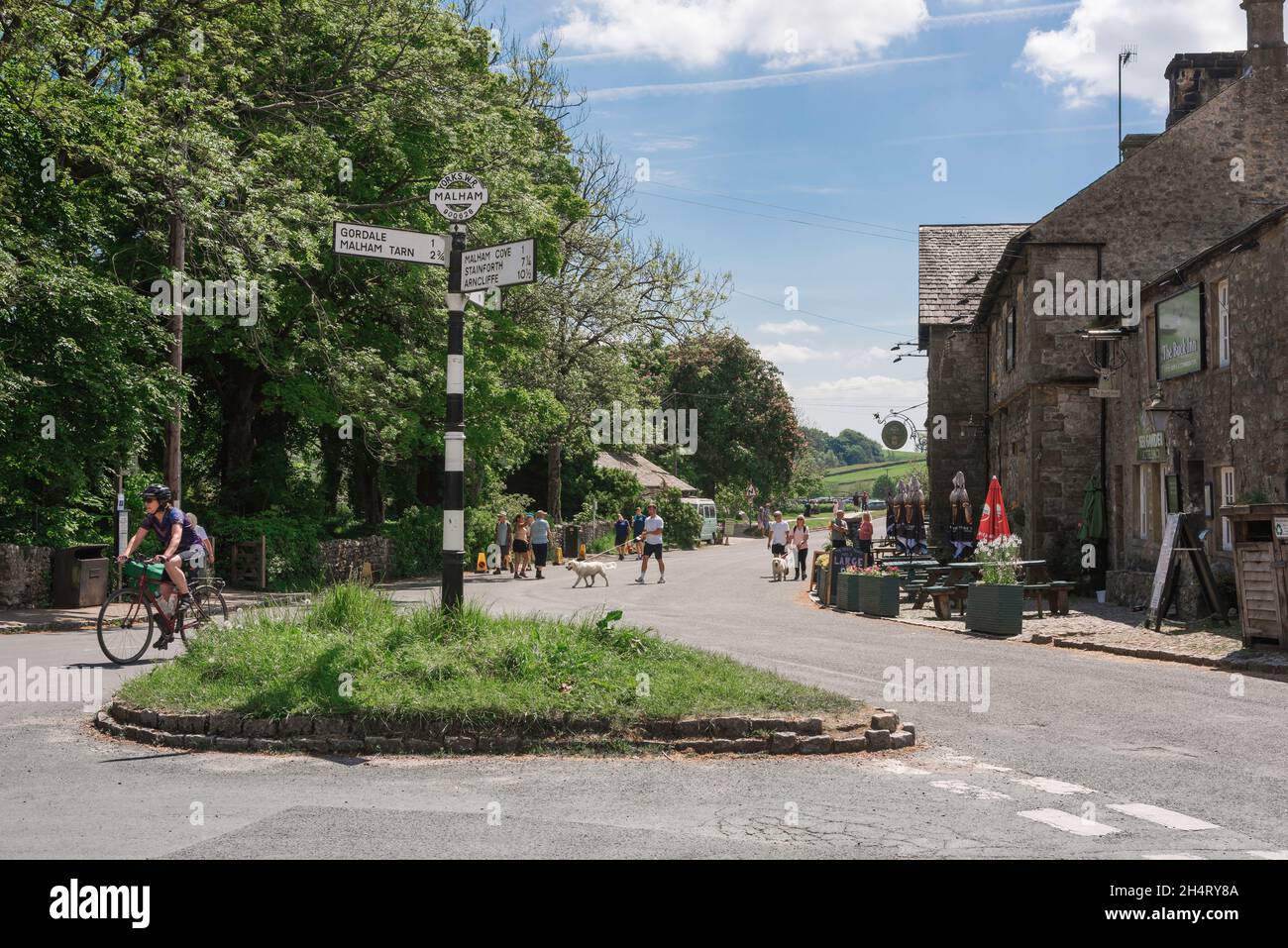 Malham Village, view in summer of the vintage signpost at the centre of ...