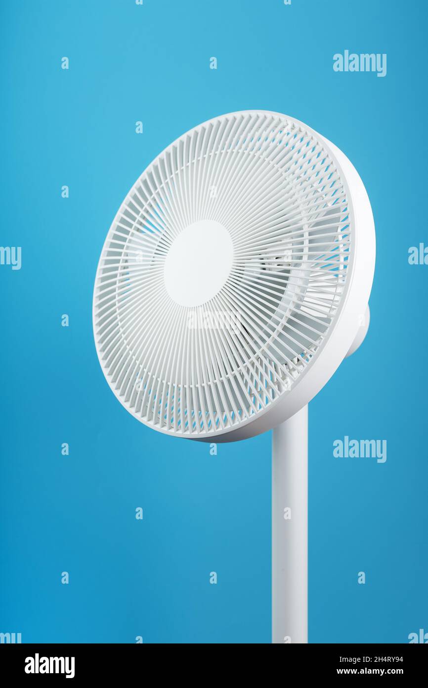 A high-tech white electric fan with a modern design for cooling the ...