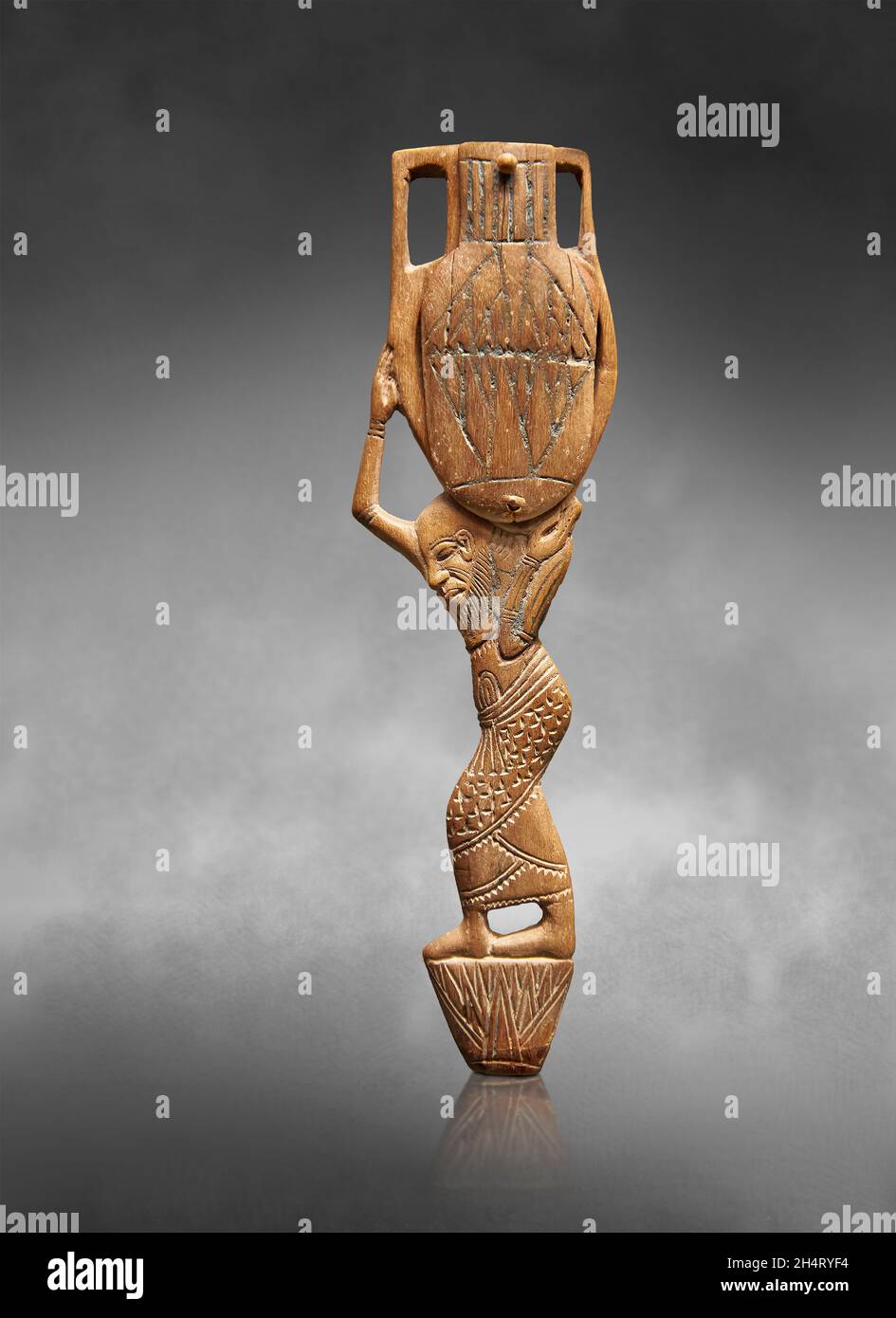 Ancient Egyptian wood cosmetic shadow spoon of a servant carrying an ...