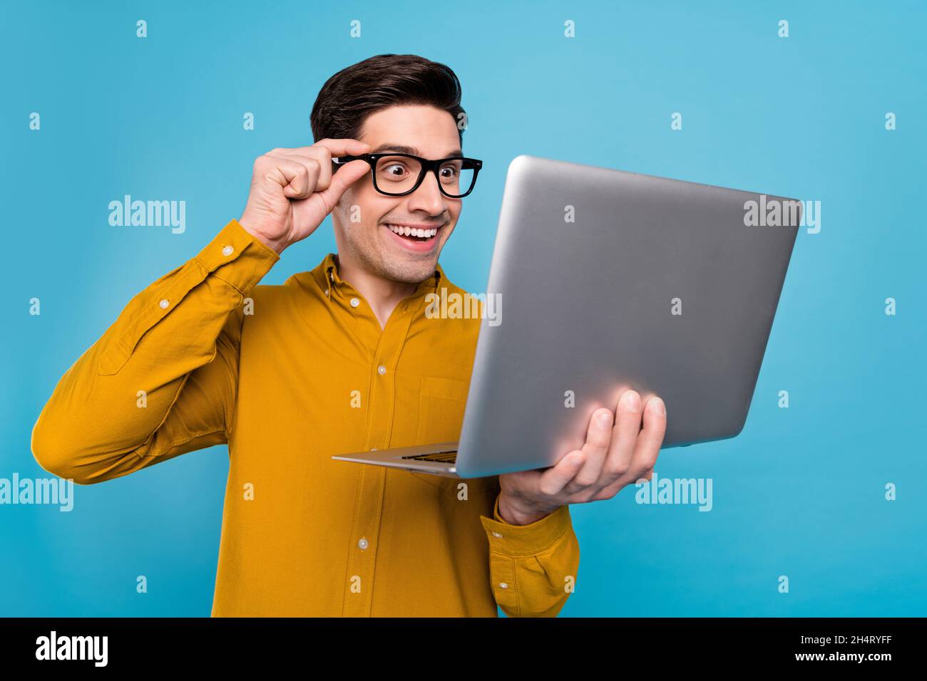 Photo of funny geek nerd guy hold pc look screen wear eyewear yellow ...