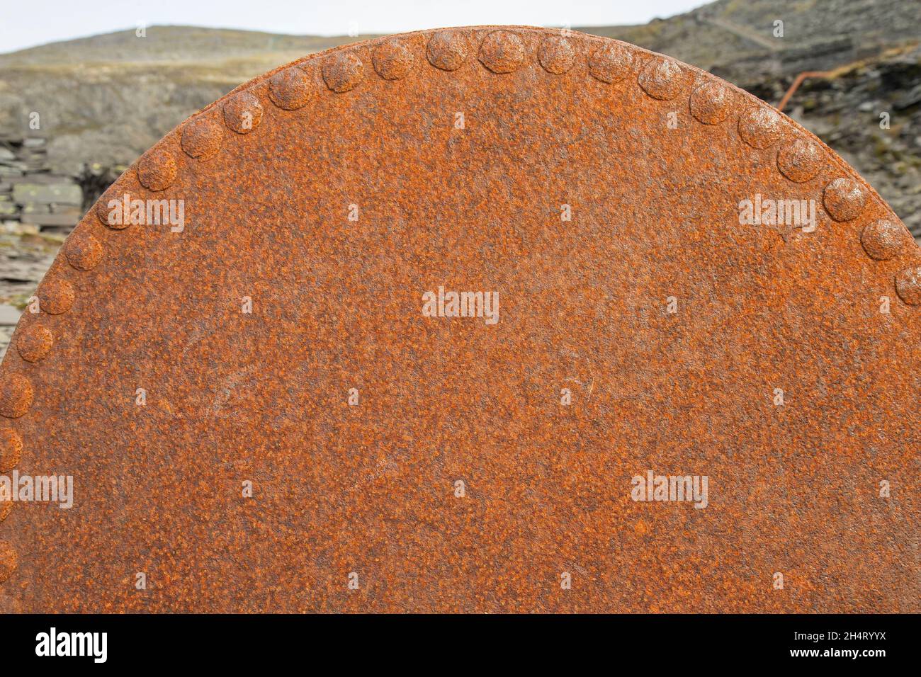 Rusty rivets on corroded metal machinery part in disused slate quarry ...