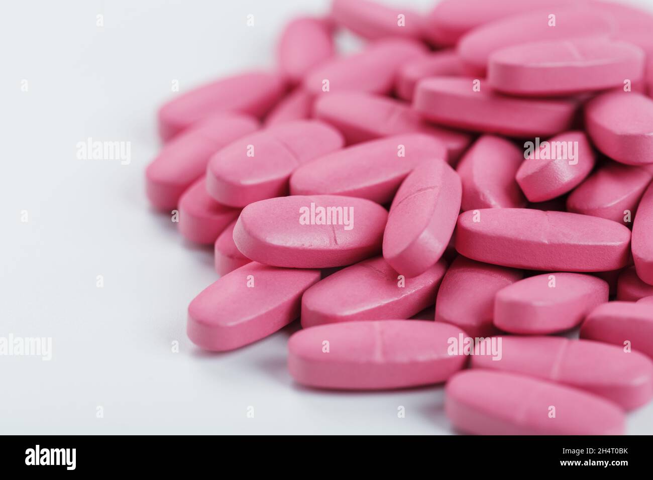 Pink vitamin pills for women on a white background. Multivitamins for ...