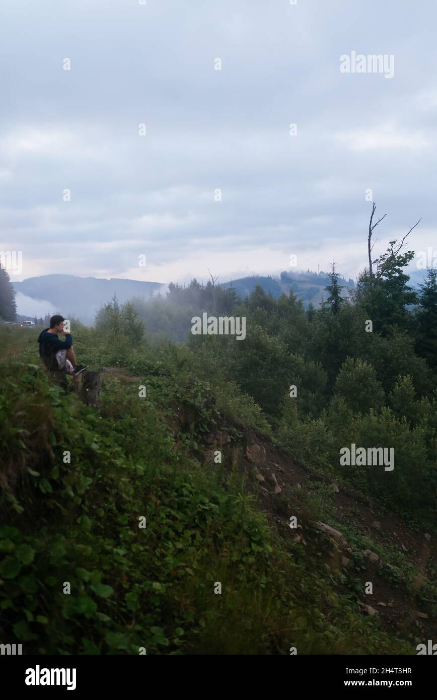 Guy top of a hill enjoying view of nature Stock Photo - Alamy