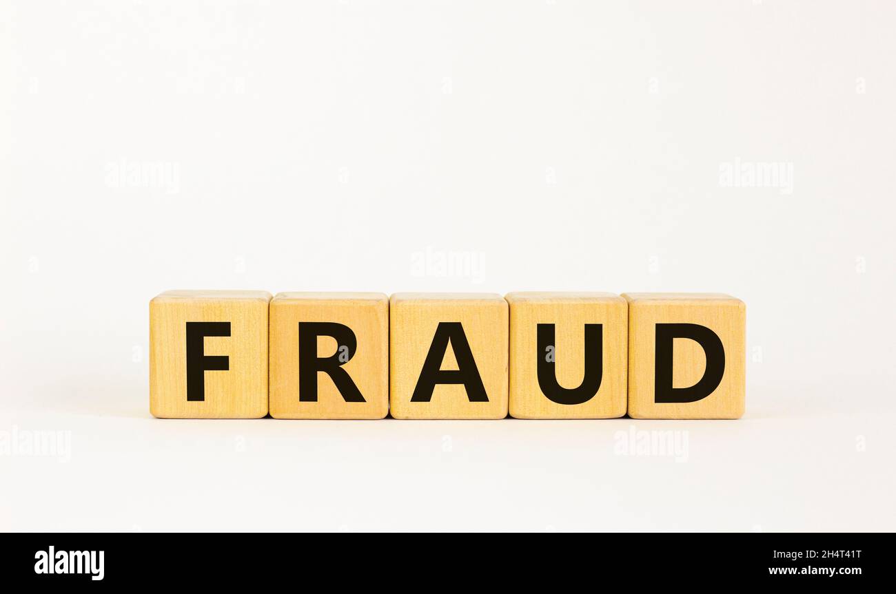 Fraud symbol. The concept word 'fraud' on wooden cubes on a beautiful ...