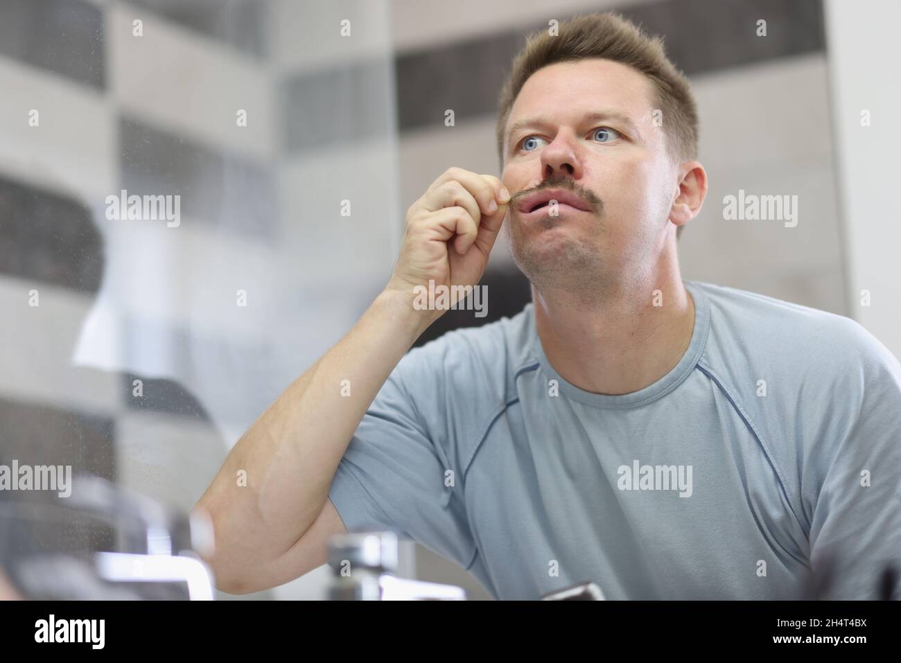 Portrait of man pull his mustache with hand, fake mustache, no beard ...